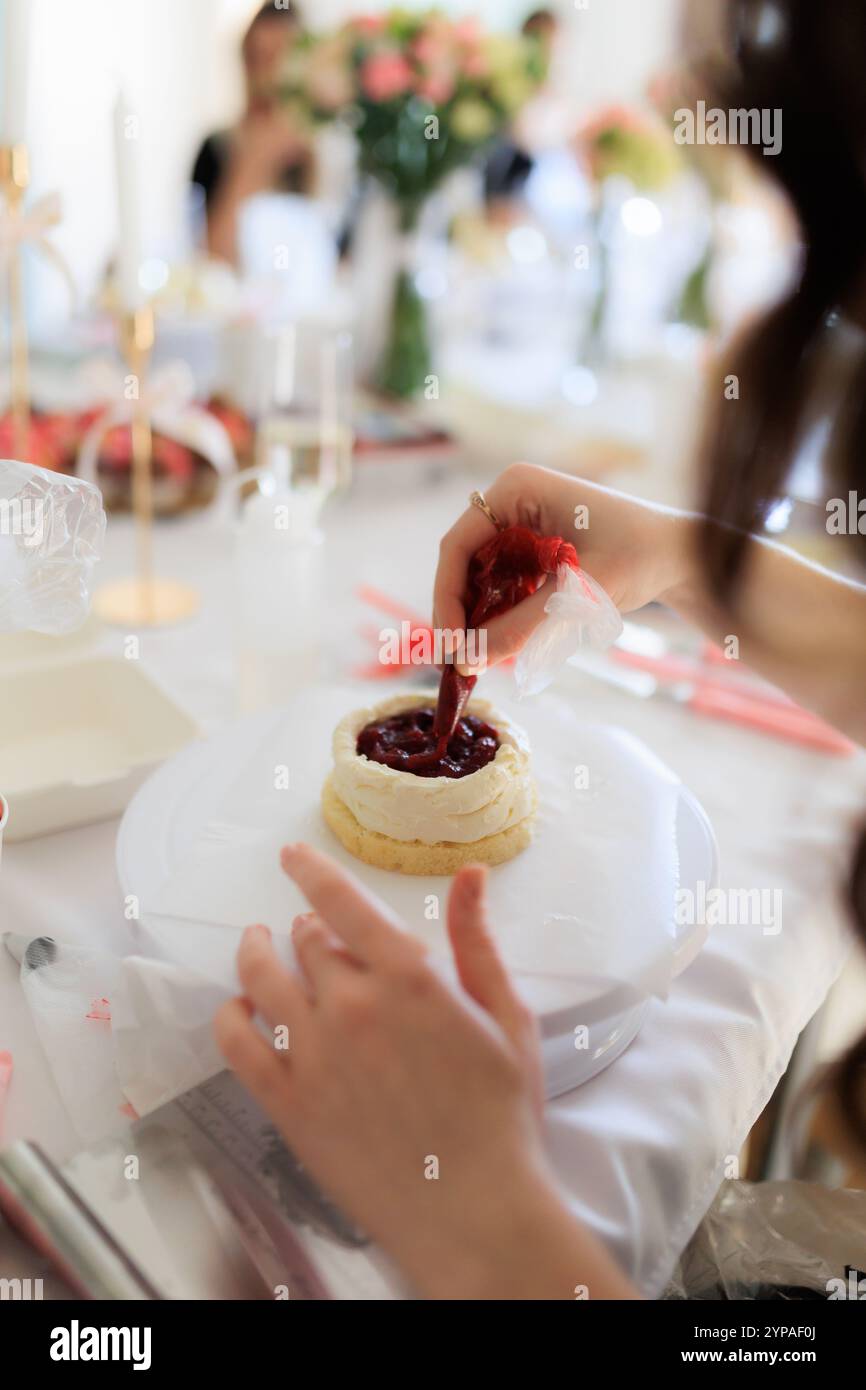 Adding berry filling. Process of creating a bento cake Stock Photo - Alamy