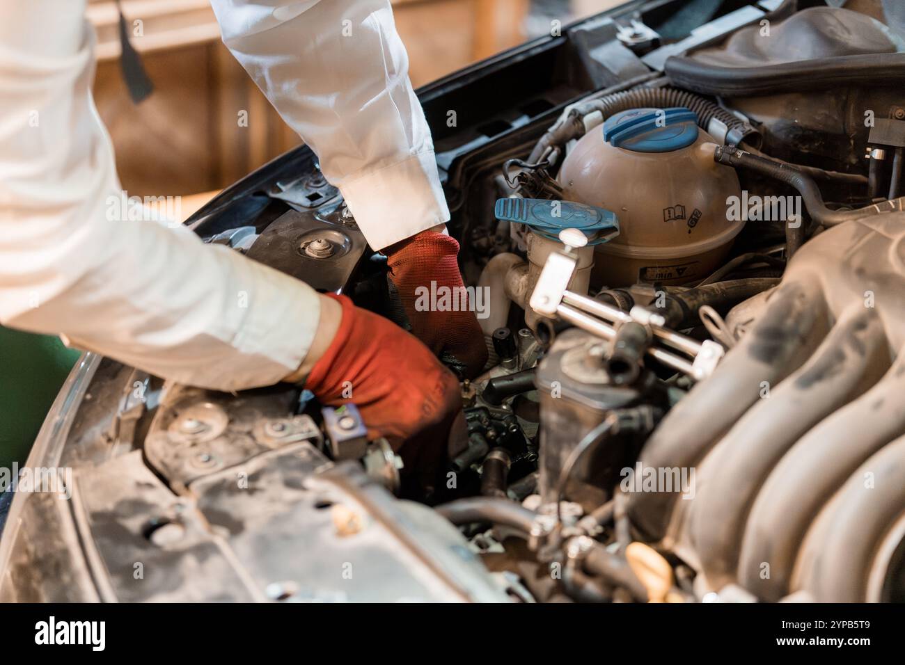 Car Mechanic Working on Engine Components Under Hood Stock Photo - Alamy