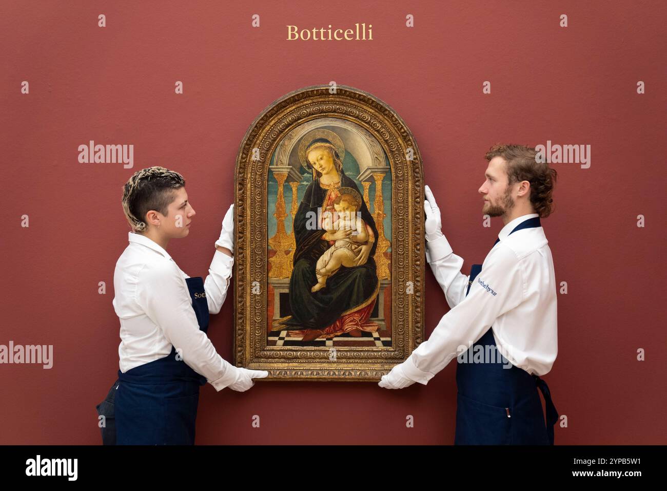 Art handlers hold Sandro Botticelli's The Virgin and Child enthroned ...