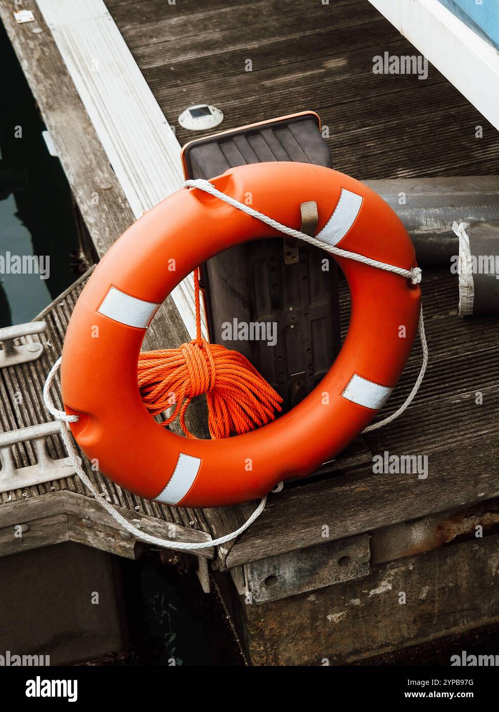 Lifebuoy in the marina. Life safety ring of a red buoy on a pole on the river bank Stock Photo ...