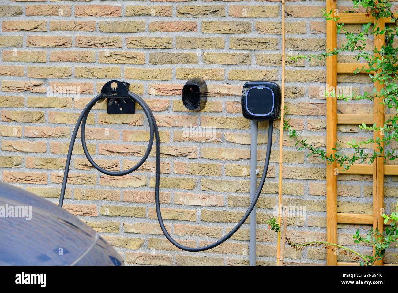 Netherlands: an EV charging, wit box mounted on a yellow brick wall ...