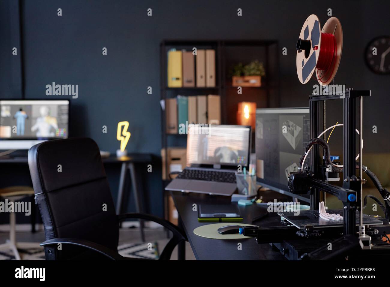 Workspace showcasing advanced 3D printer amidst contemporary office setting. Monitor displaying ...