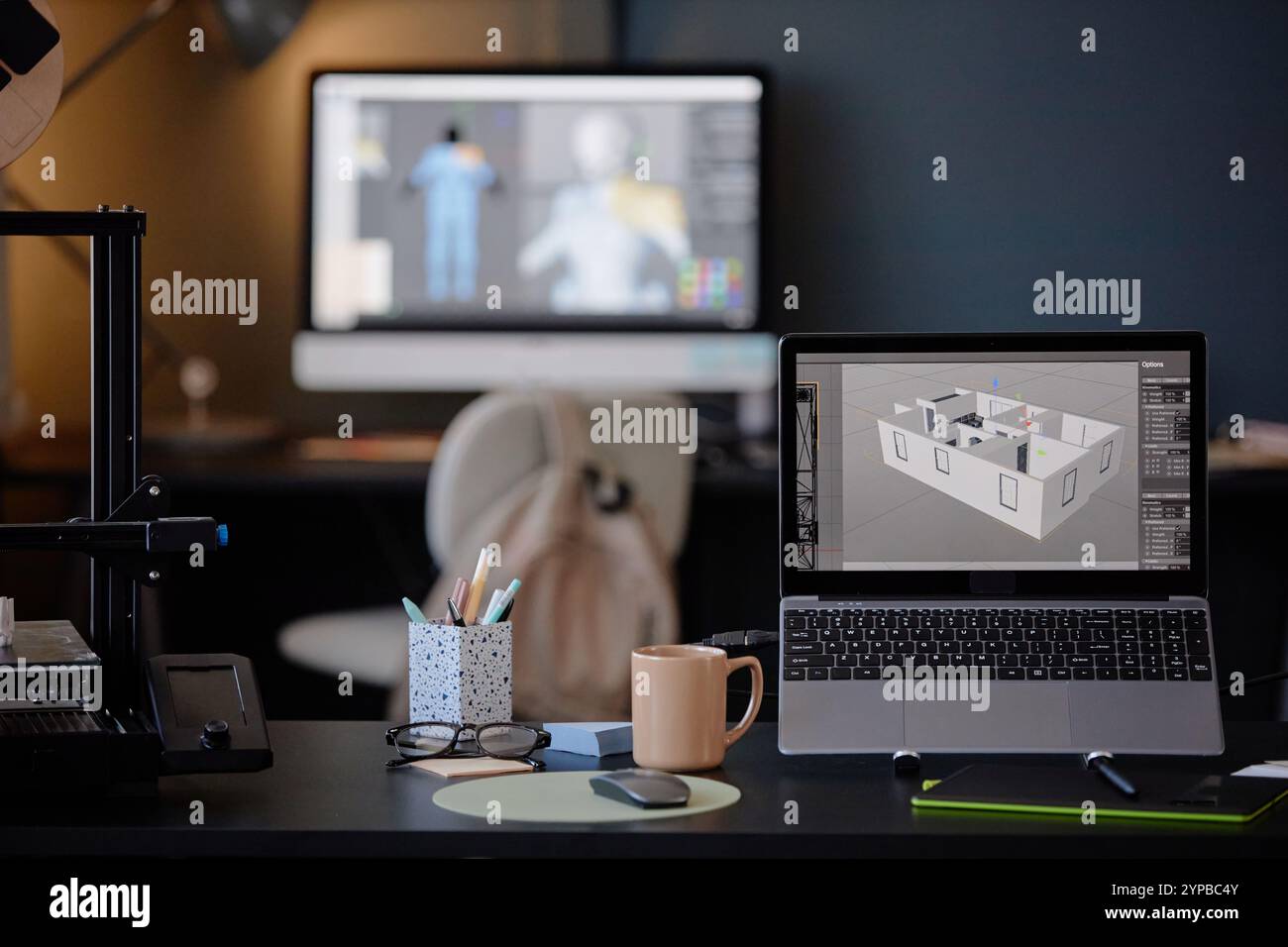 Office desk setup with laptop showing architectural designs and screens ...