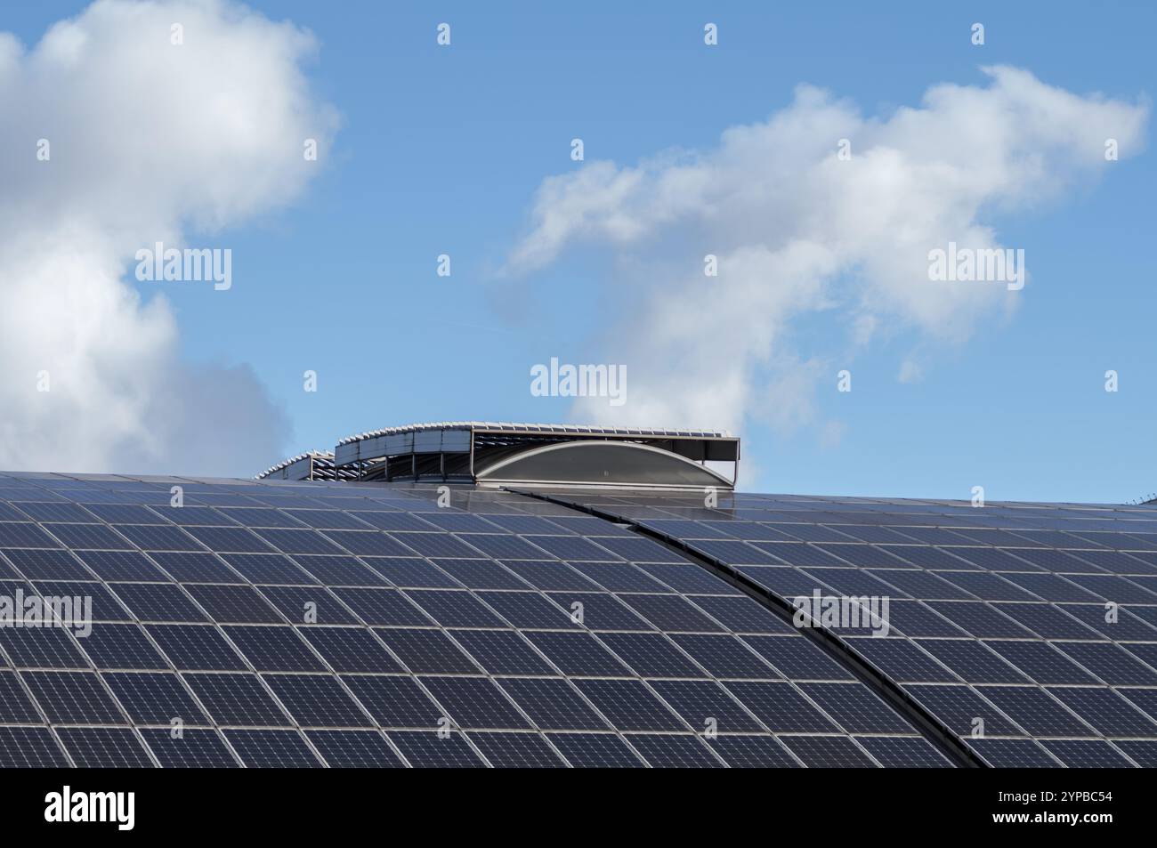 Solar panel system on a curved rooftop capturing sunlight under a ...