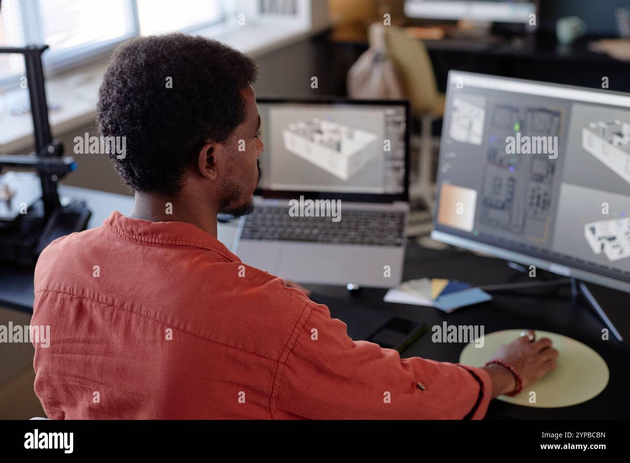 Person wearing red shirt designing architectural floor plans on ...