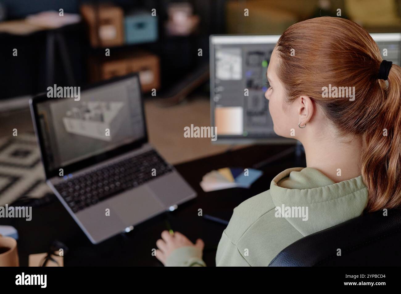 Person sitting at desk and observing design layout on computer screen ...