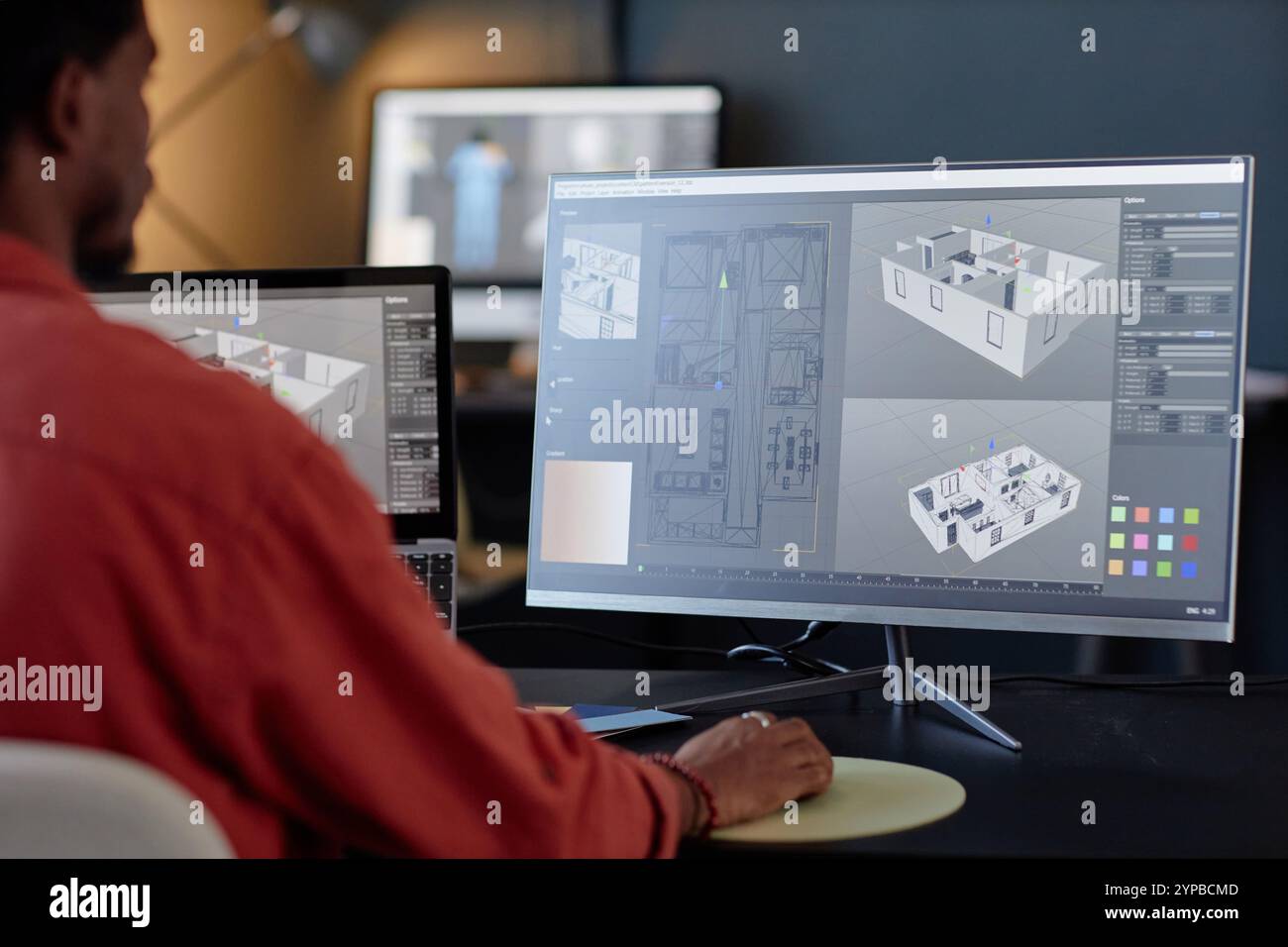 Man working on architectural designs on dual computer screens in an ...