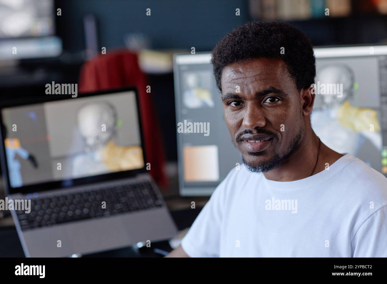 Portrait of African American man standing near computer screen in ...