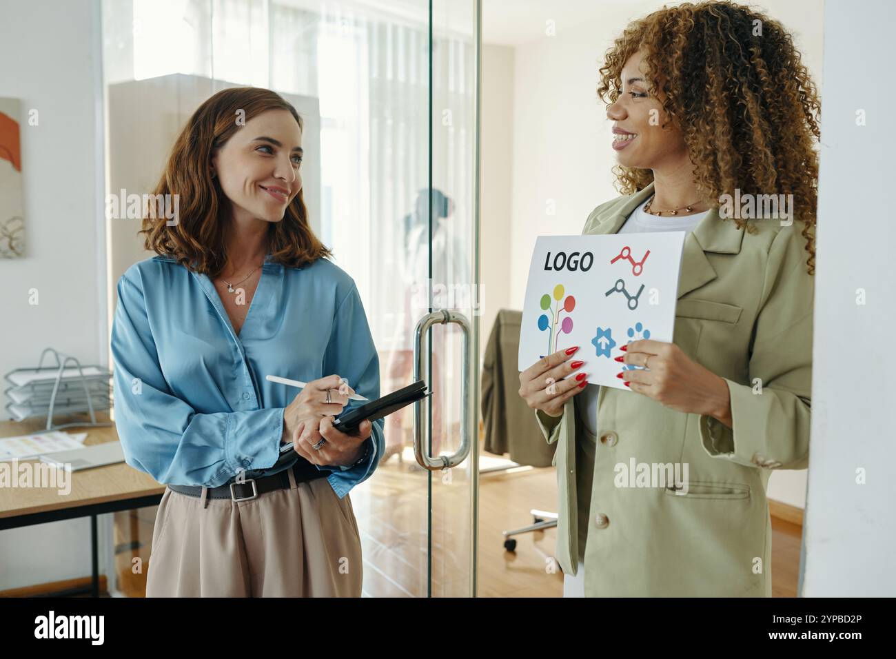 African American woman presenting logo design while colleague with ...