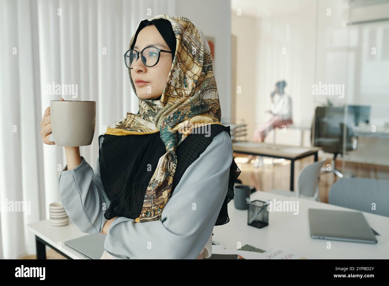 Contemplating Day with Coffee in Modern Office Setting Stock Photo - Alamy