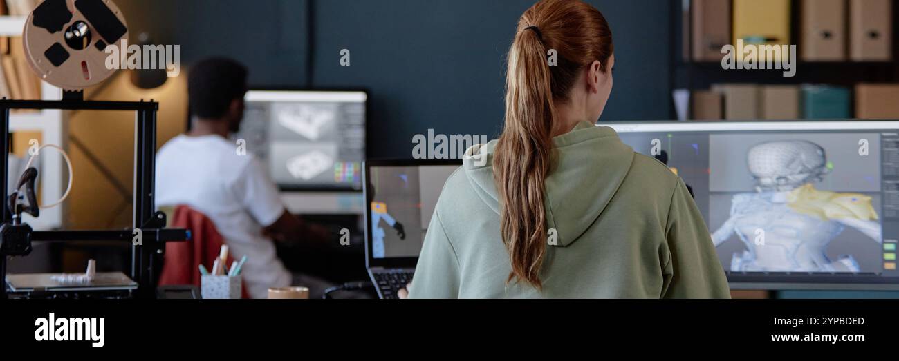 Workers collaborating on digital 3D models in a modern workspace with ...