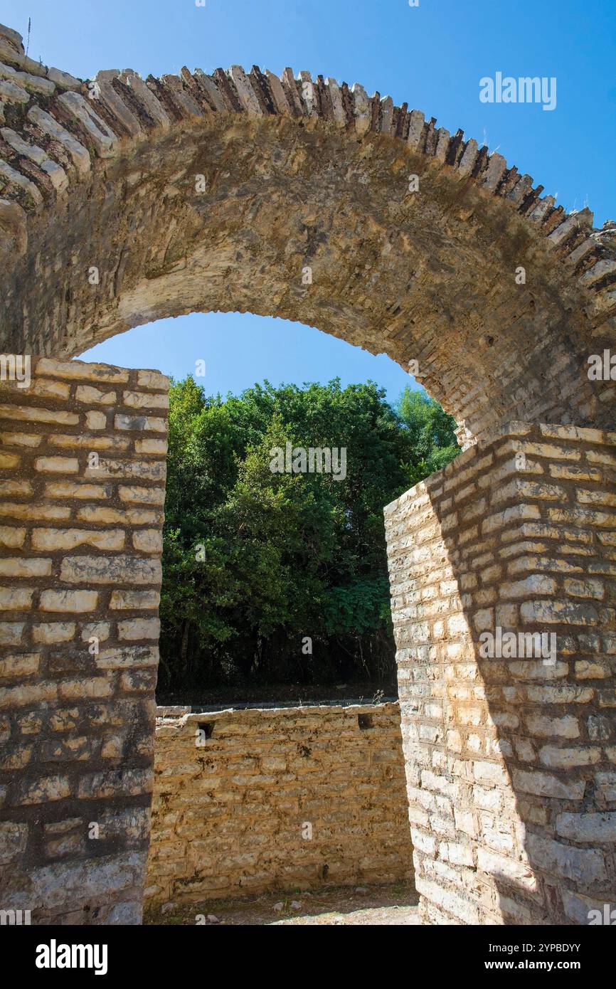 The arched entrance to the 3rd century Roman Amphitheatre in Butrint Archaeological Park, within ...