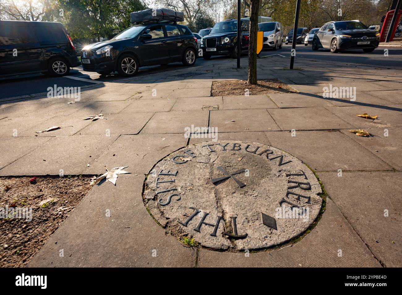 A circular plaque embedded into the pavement on a traffic island at the ...