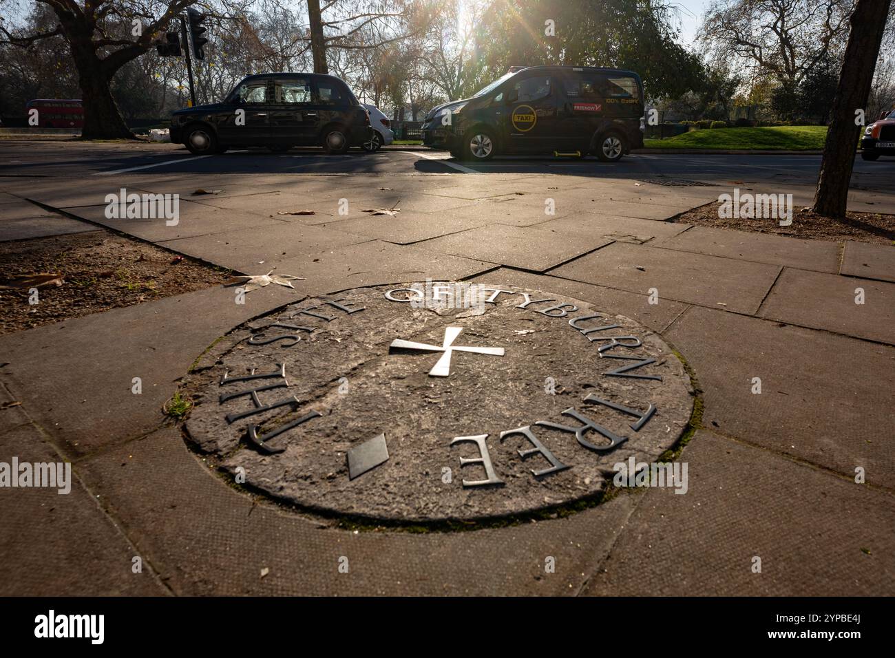 A circular plaque embedded into the pavement on a traffic island at the ...