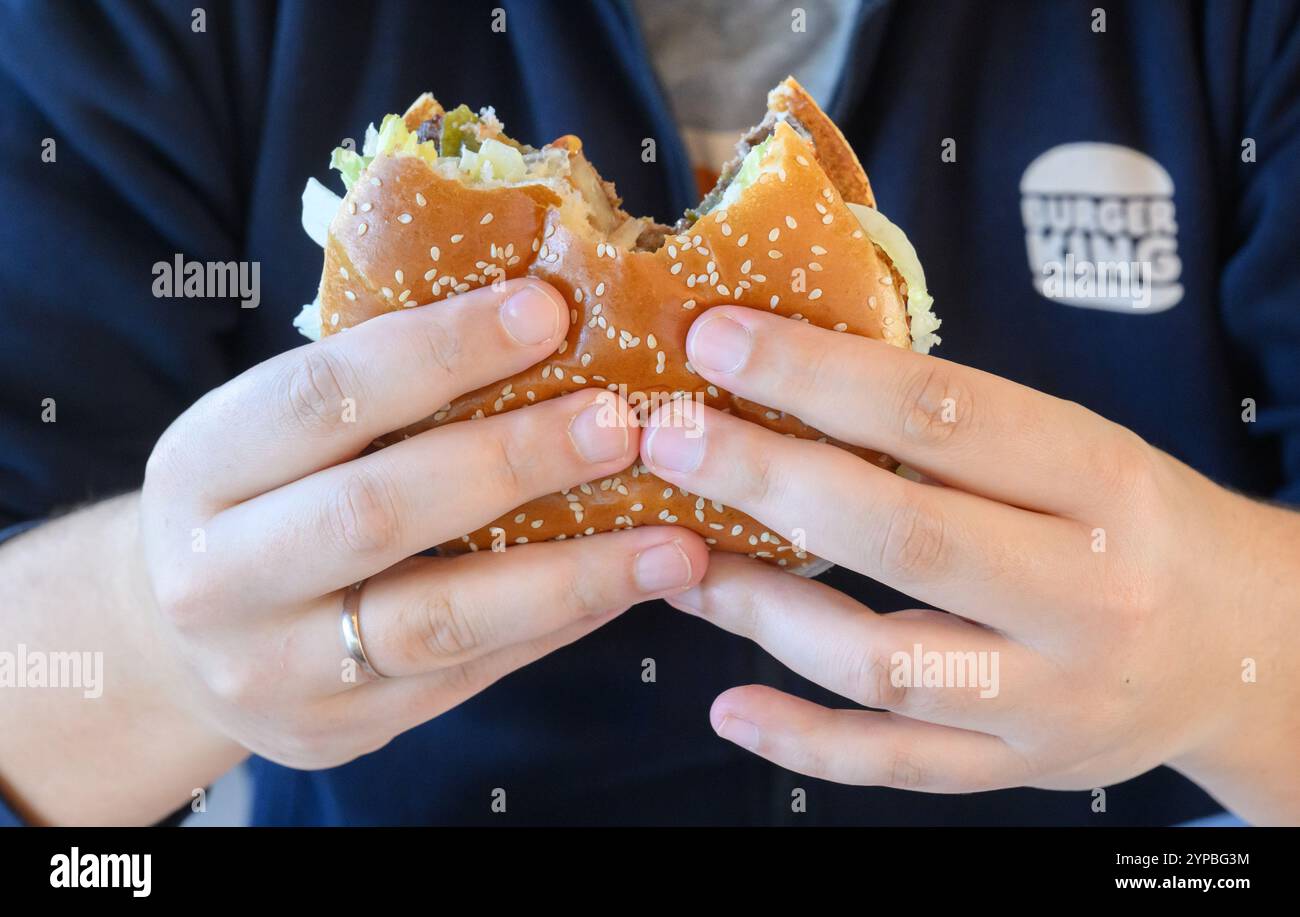 Hanover, Germany. 29th Nov, 2024. ILLUSTRATION - A man eats a Burger ...