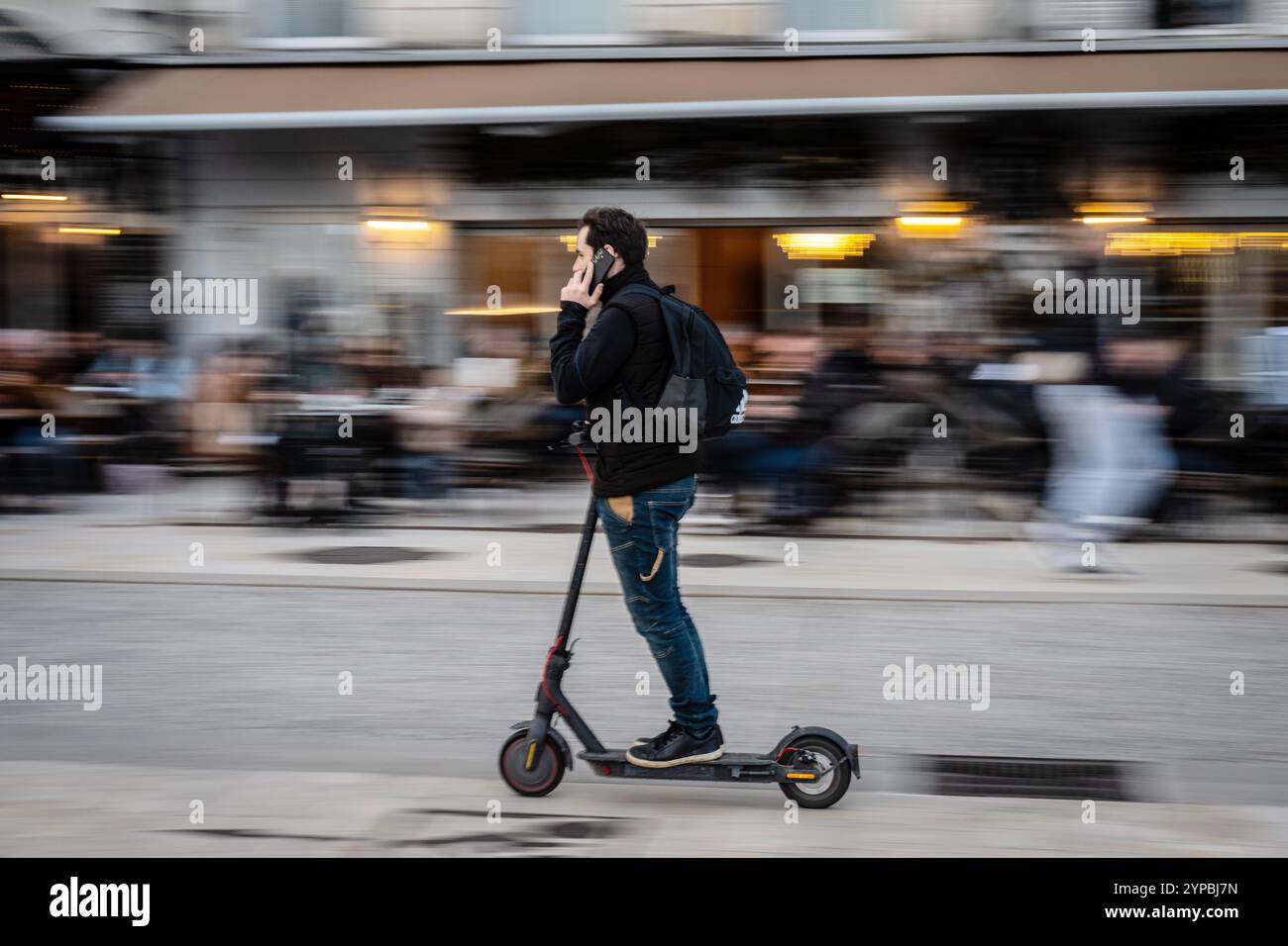 Someone making a phone call while riding an electric scooter *** Local ...