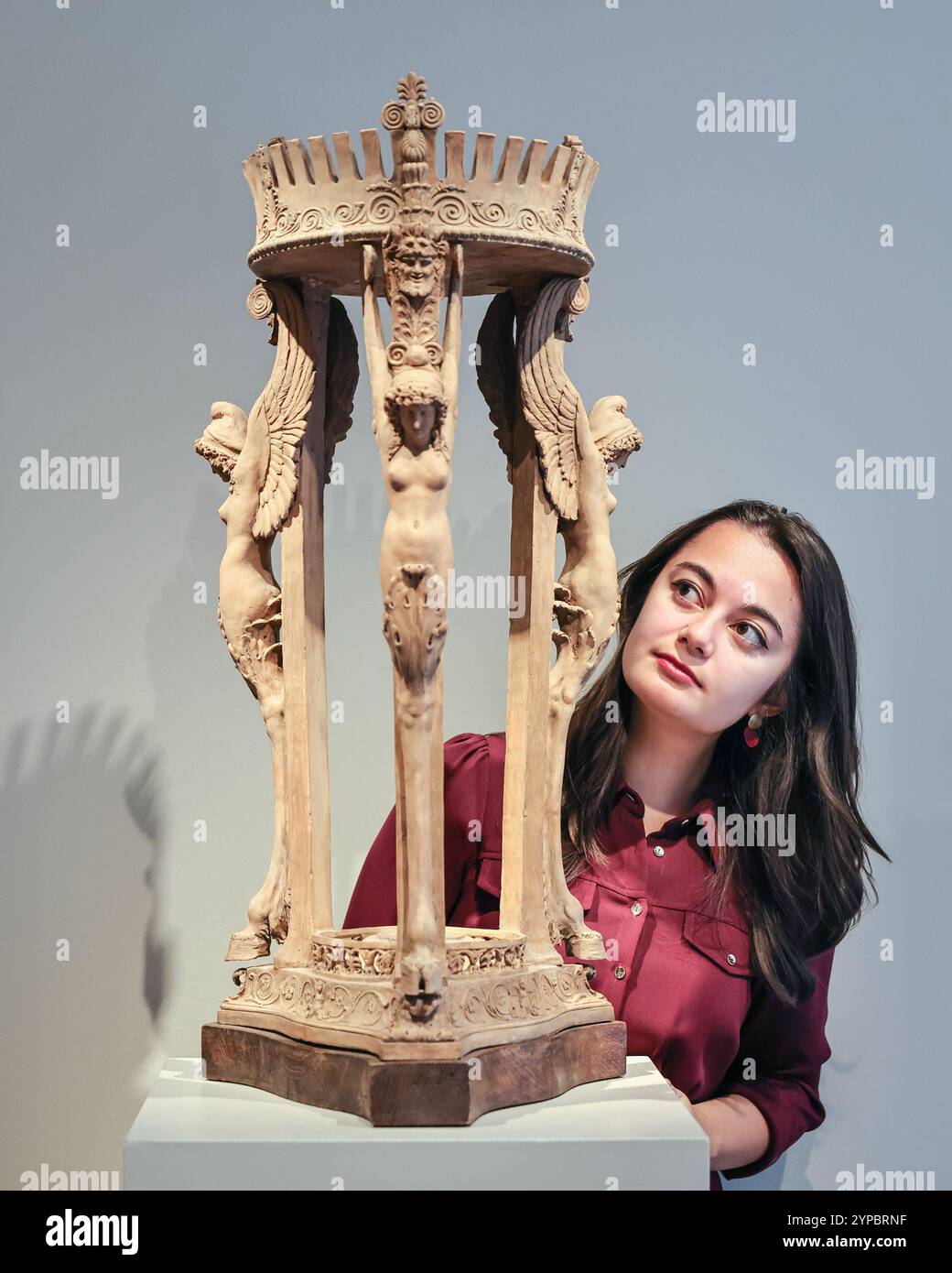 London, UK. 28th Nov, 2024. Staff with an 18th ct tripod statue by ...