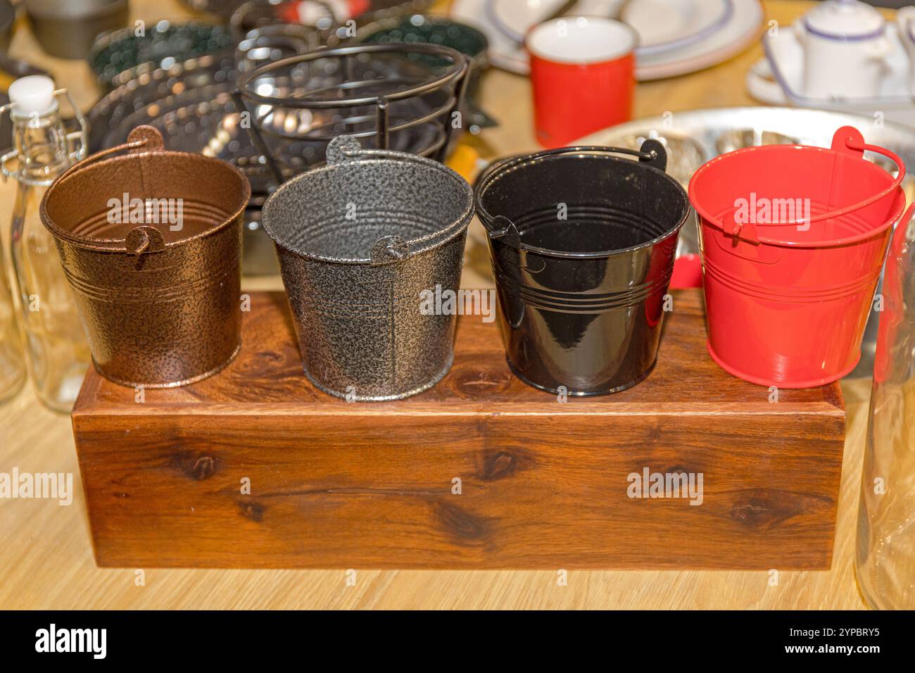 Four Small Metal Buckets in Different Colours at Block of Wood Table ...