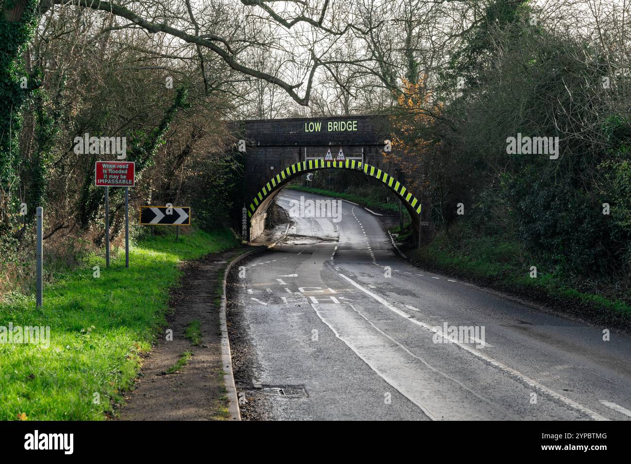 Low bridge warning sign and chevron hazard markings on a narrow country ...