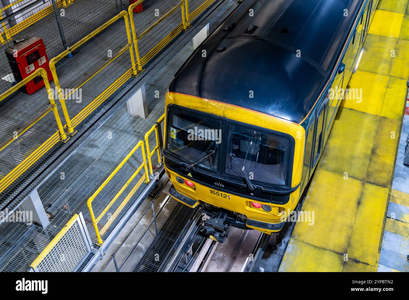 Yellow and blue train entering maintenance area in depot Stock Photo ...