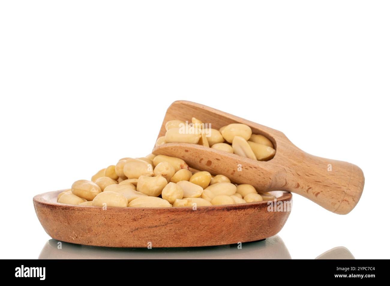 Roasted delicious peanuts on a wooden plate, close-up, isolated on a ...