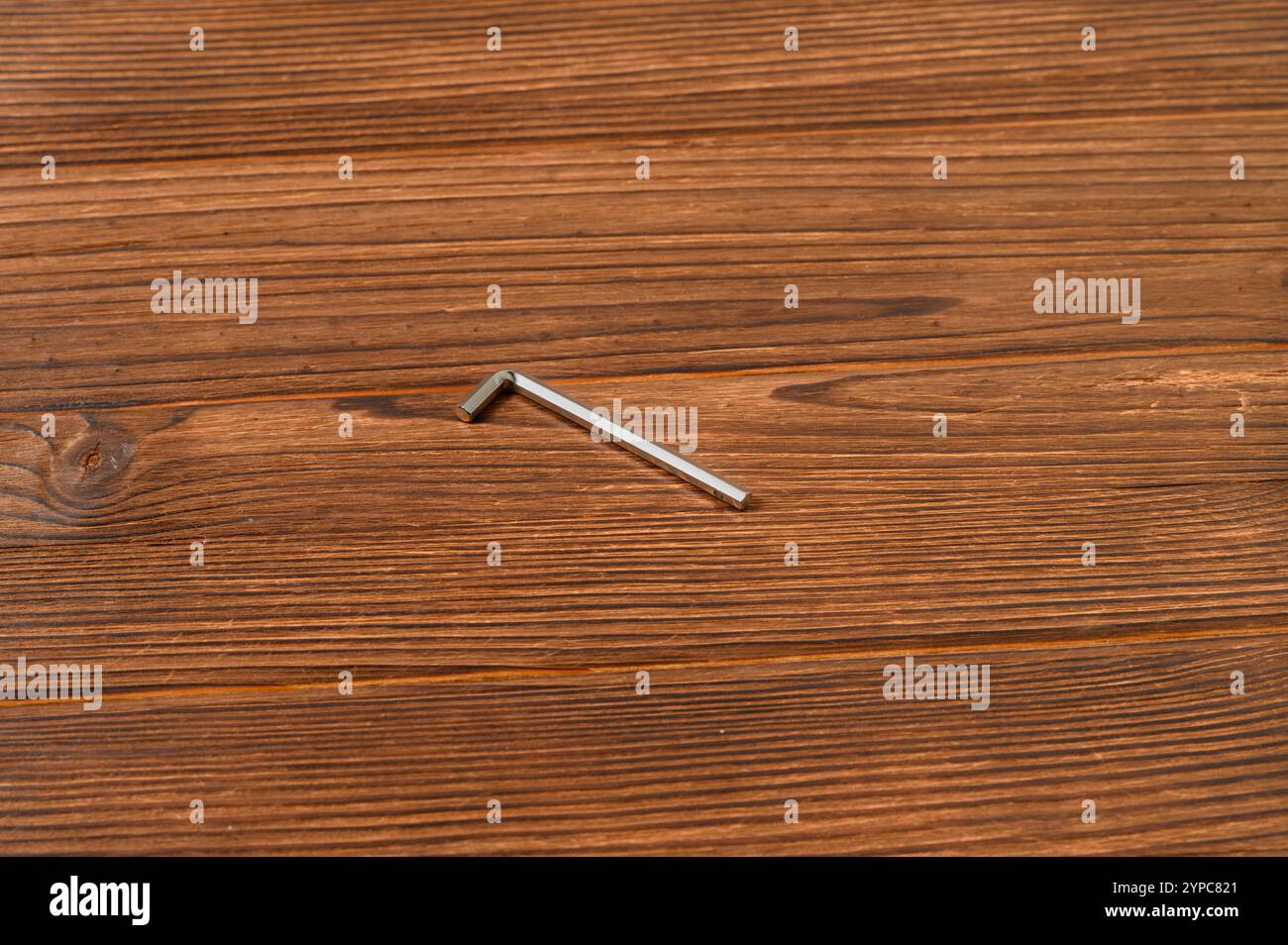 This image shows a small metal Allen key L-Keys lying on a wooden ...