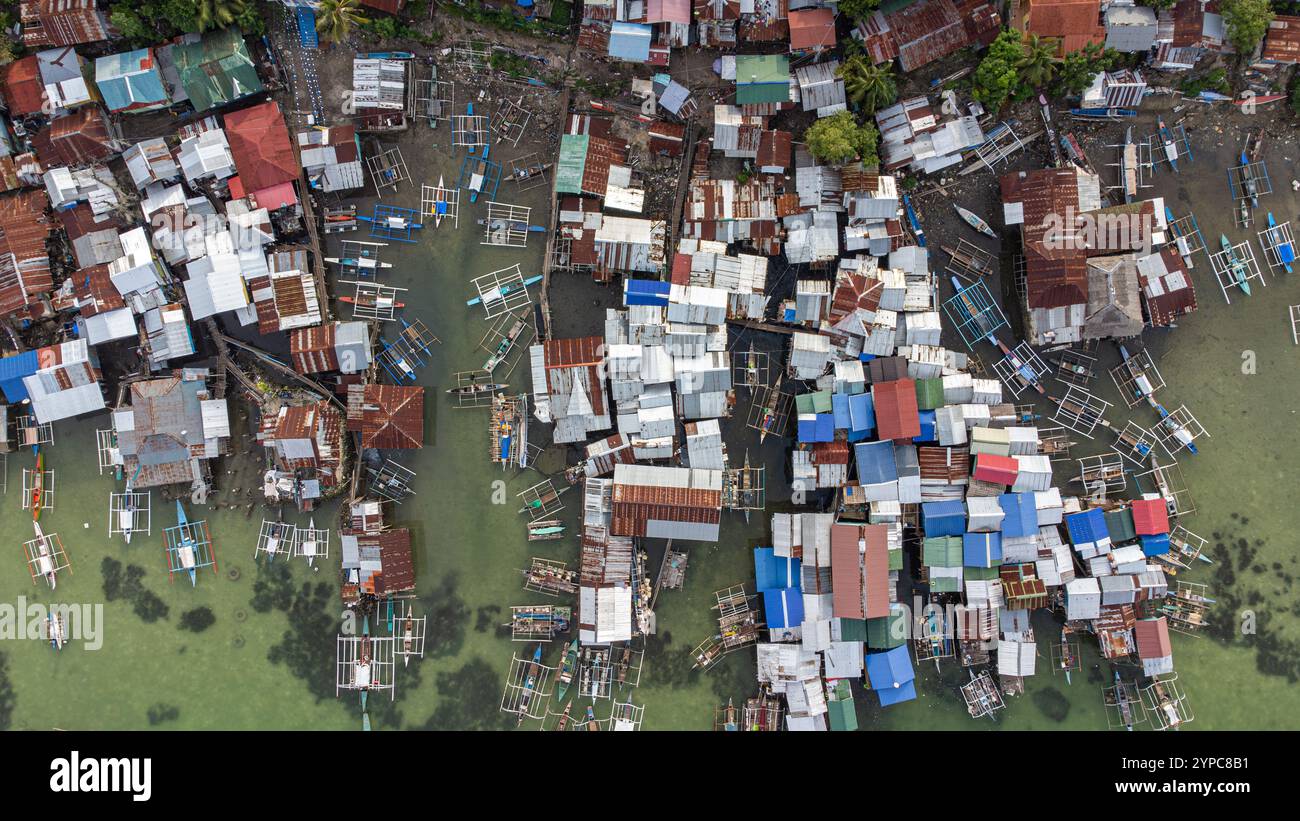 Fishing boats and stilt houses over the water in Bohol, Philippines ...