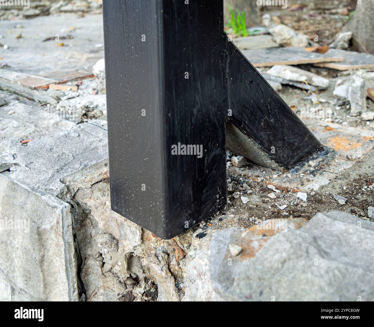Fastening a fence support to a foundation using a brace Stock Photo - Alamy