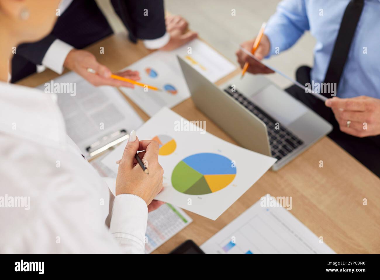 Team discussing document with pie charts close up, business people ...