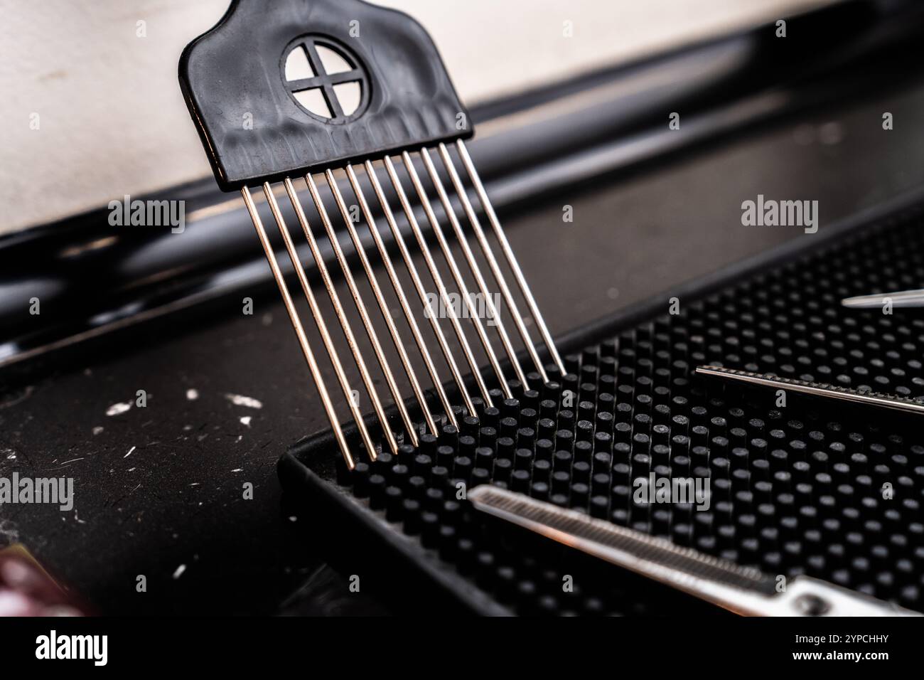 Unique metal styling comb positioned on a hairstylists workstation ...
