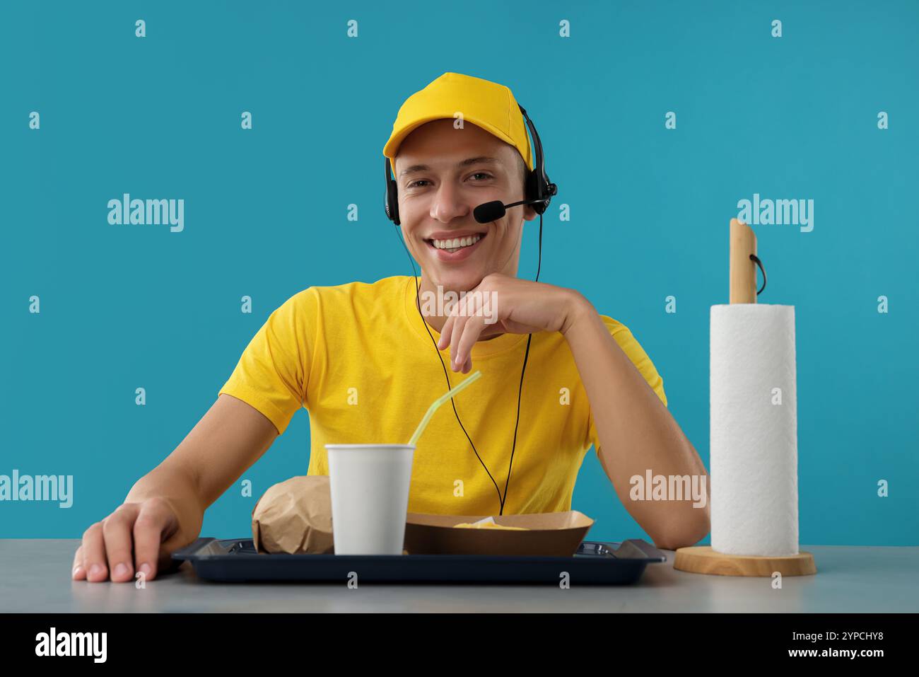 Fast-food worker with order at counter against light blue background ...