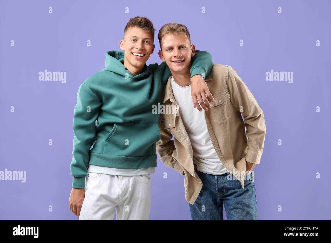 Portrait of happy brothers on violet background Stock Photo - Alamy