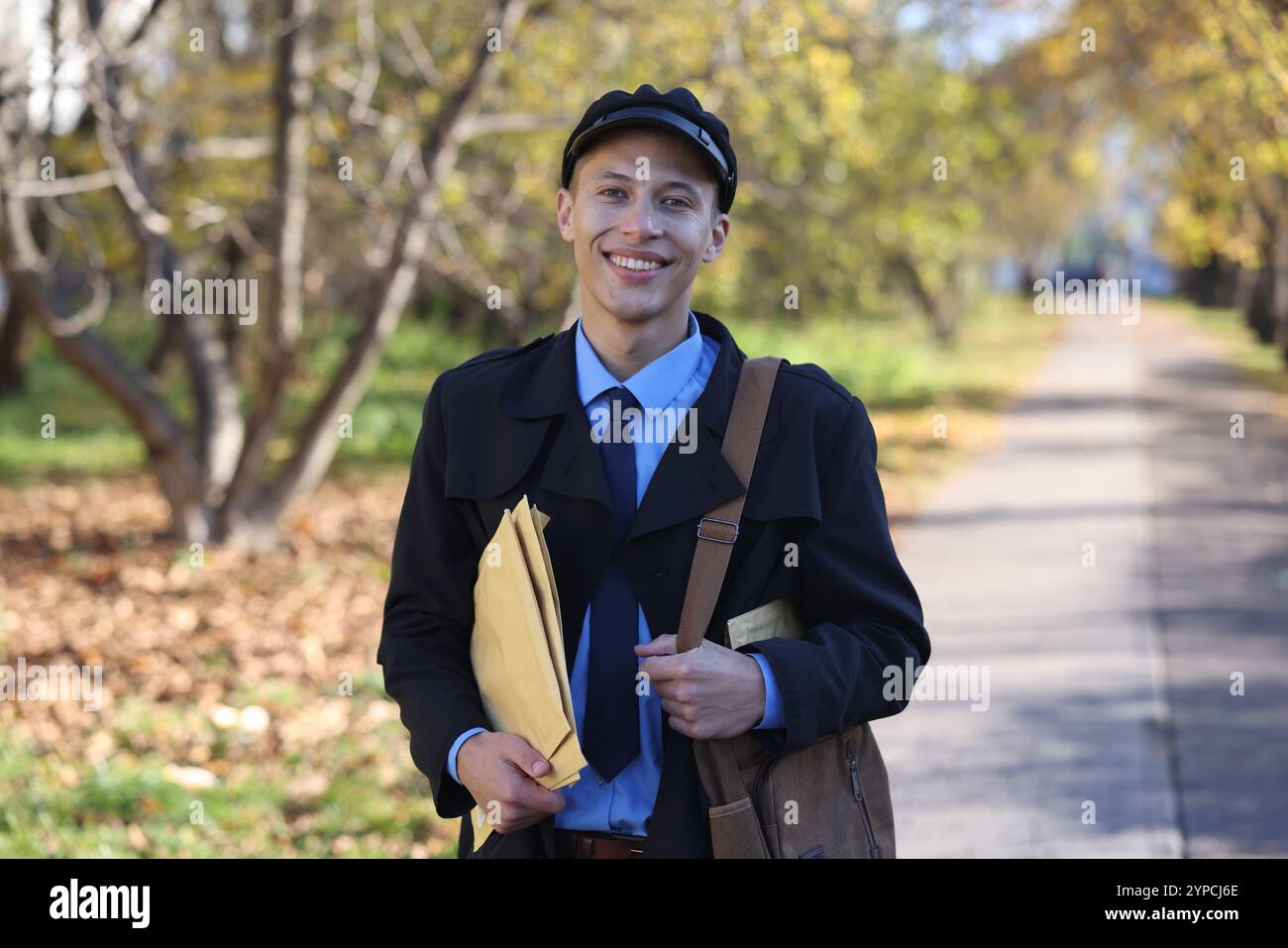 Happy postman with bag and envelopes outdoors Stock Photo - Alamy