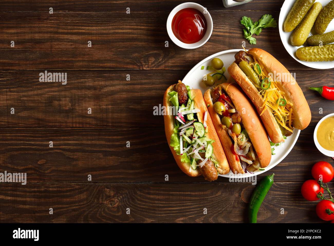 Hot dogs loaded with assorted toppings on wooden background with free ...