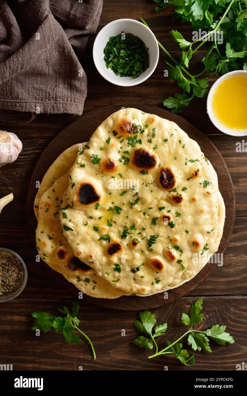 Homemade indian naan bread with garlic butter on wooden table. Top view ...
