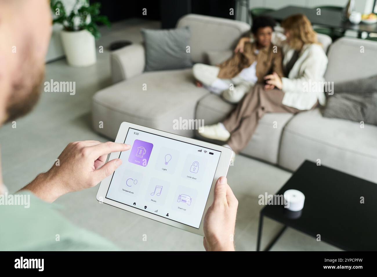 Individual using tablet for controlling smart home features while ...