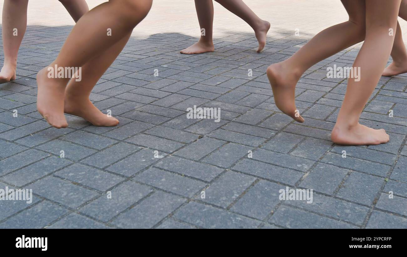 The feet of young female high school graduates run in a circle in a ...