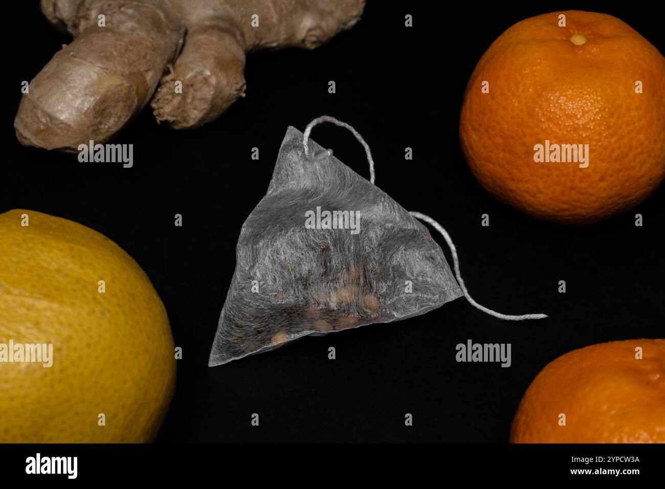 Triangular tea bag surrounded by citruses with ginger root. Natural ...