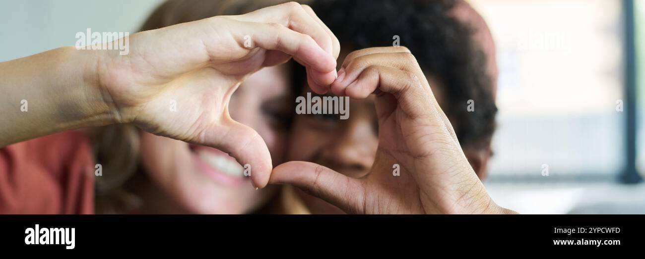 Close-up view of two people forming heart shape with their hands ...