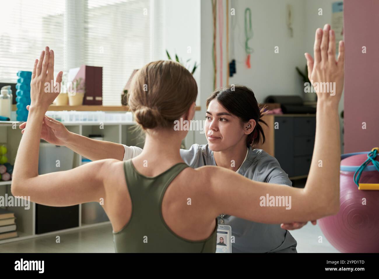 Yoga instructor guiding student through hi-res stock photography and ...