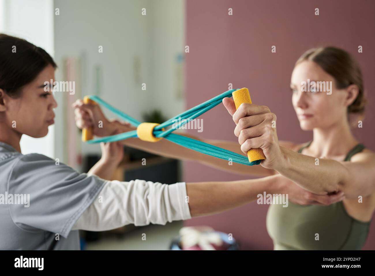 Physical therapist assisting woman by demonstrating exercise with ...