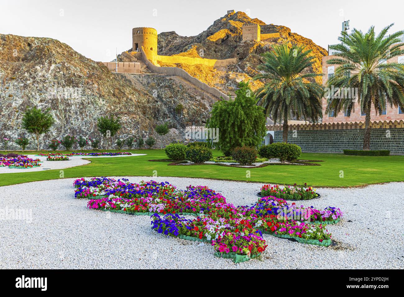Park with gravel paths, flowers and palm trees at the Sultan's Palace ...