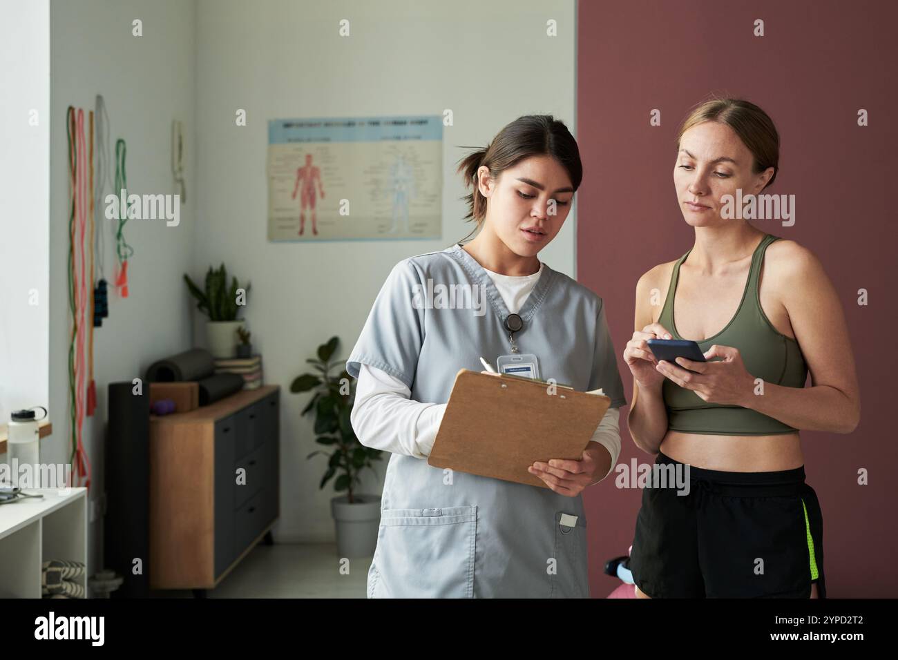 Personal trainer engaging with female client while reviewing fitness ...