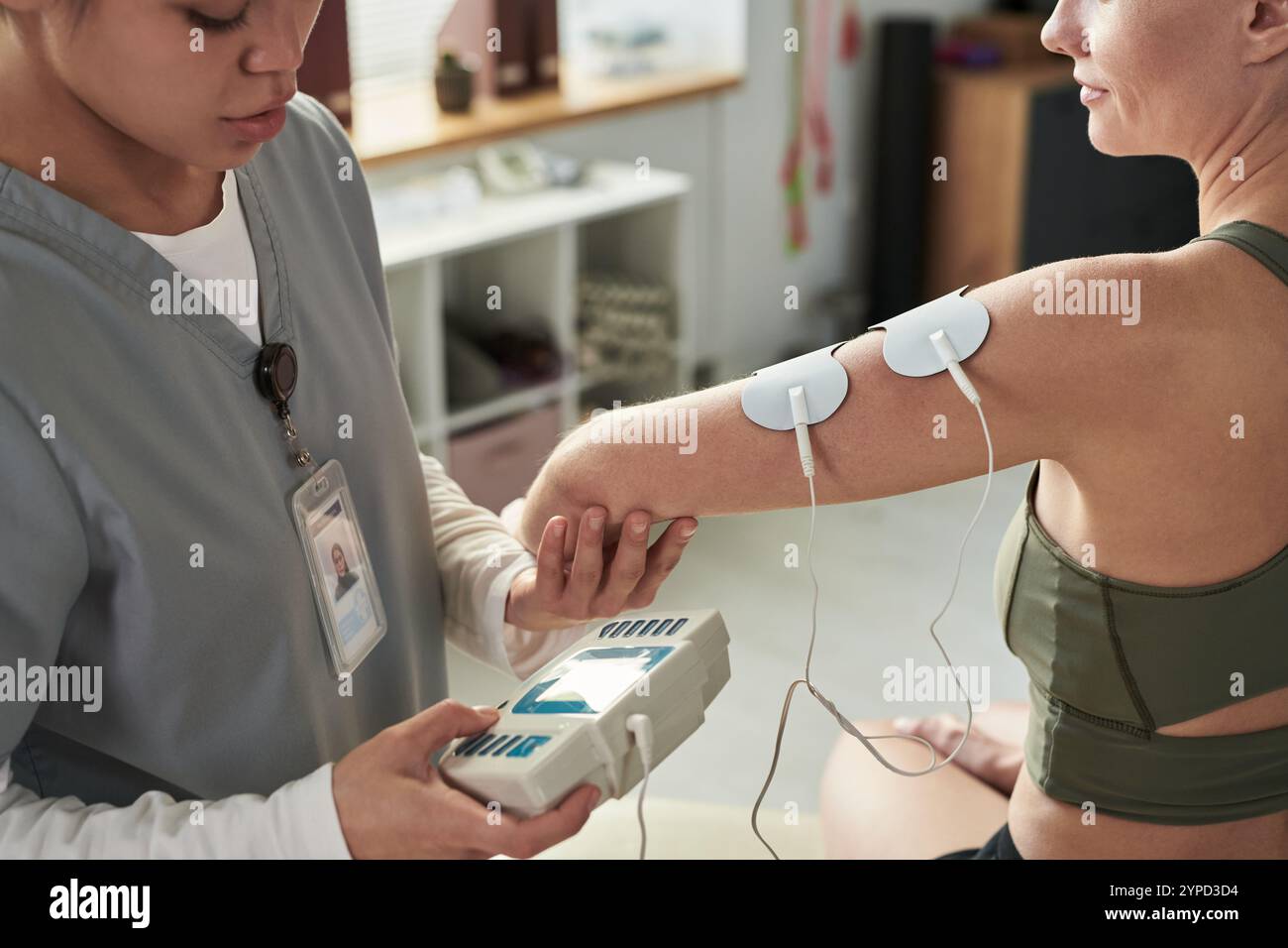 Medical professional delivering electrotherapy treatment to patient ...