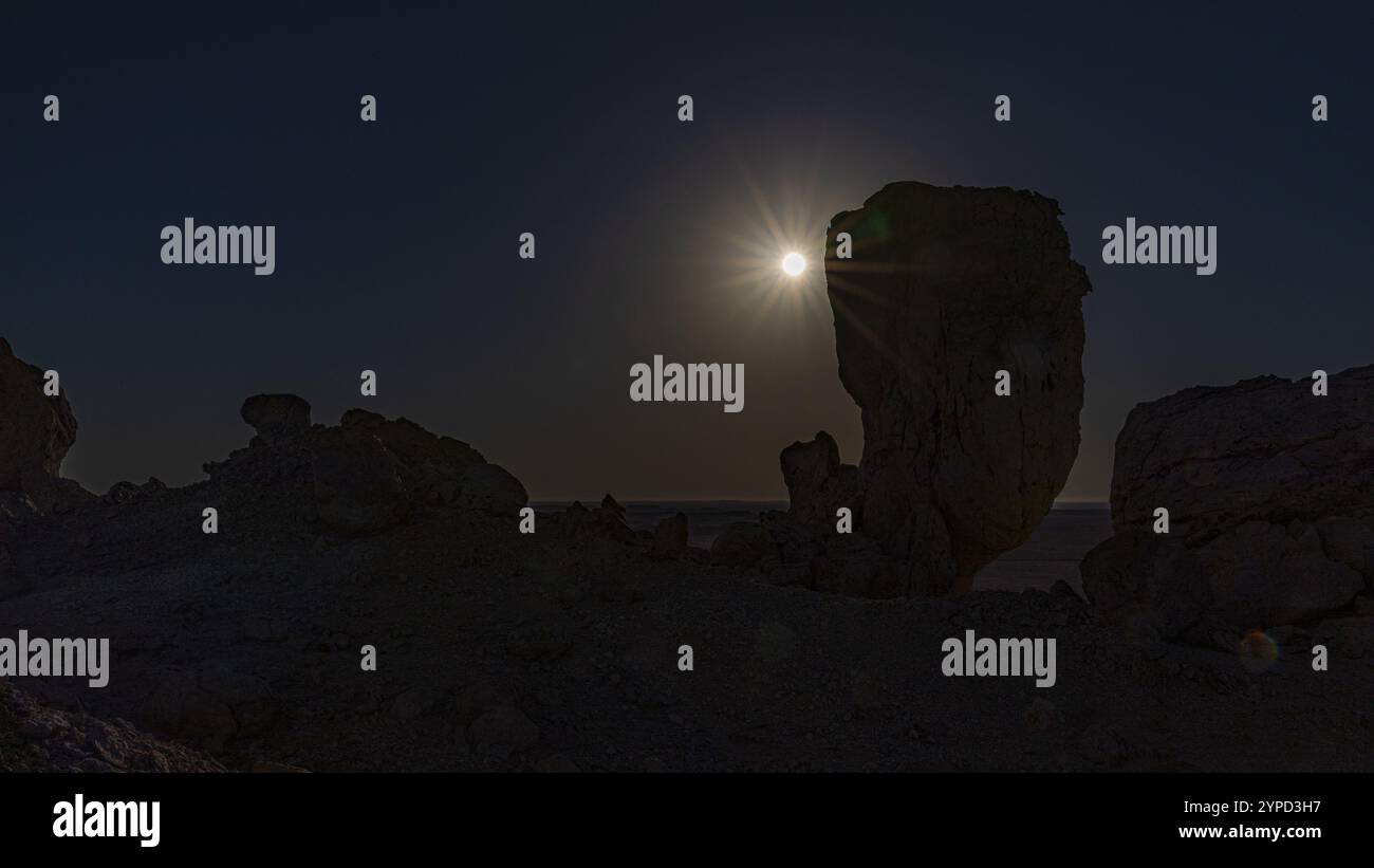 The morning sun shines through a striking rock formation in the Huqf ...