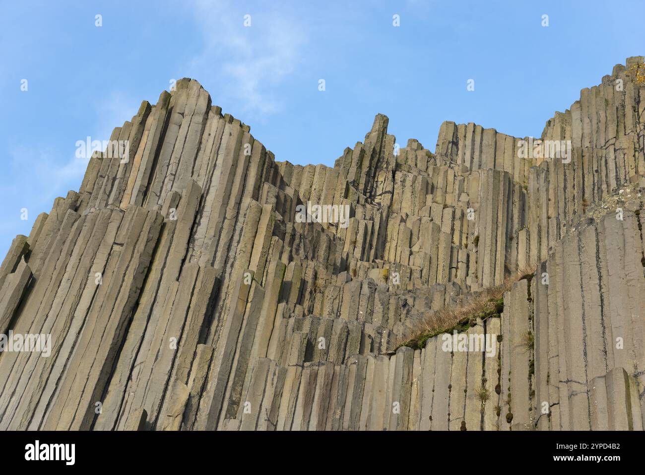 Imposing basalt walls rise majestically into the blue sky, manor house ...