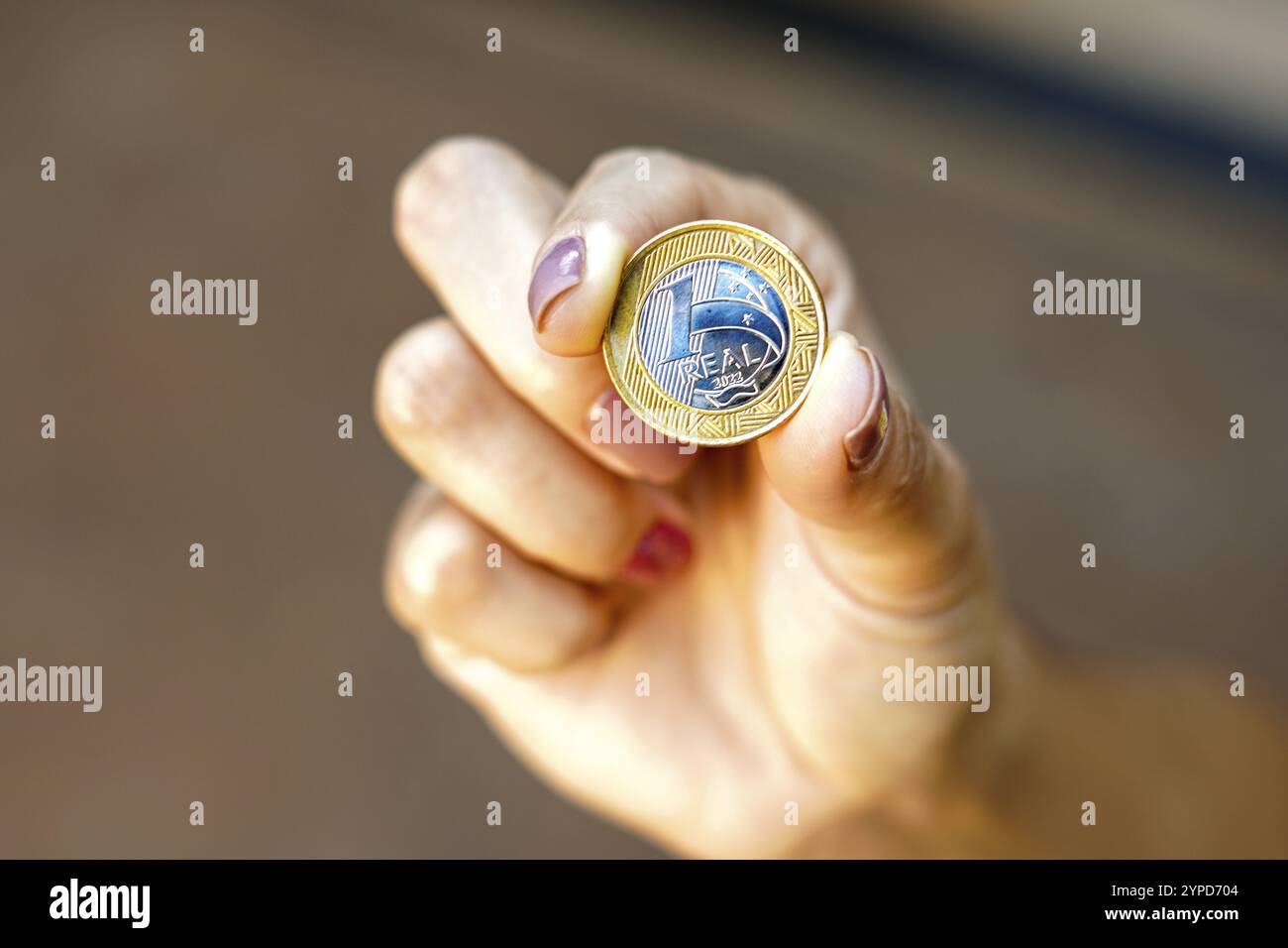April 19, 2024, Brazil. Woman holds some real coins, Brazilian money ...