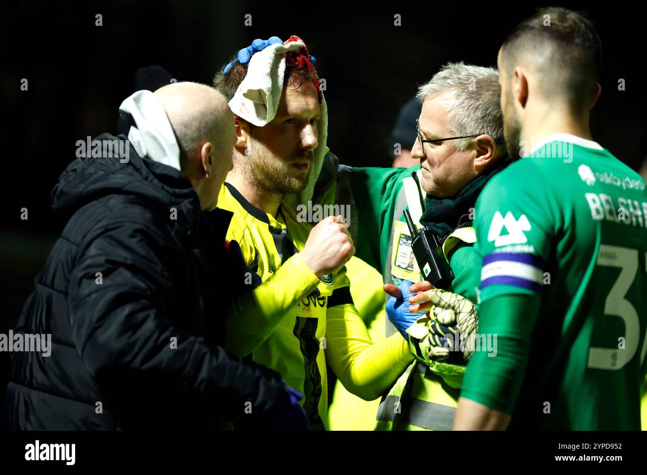 Harrogate Town's Stephen Dooley (centre) receives treatment from ...