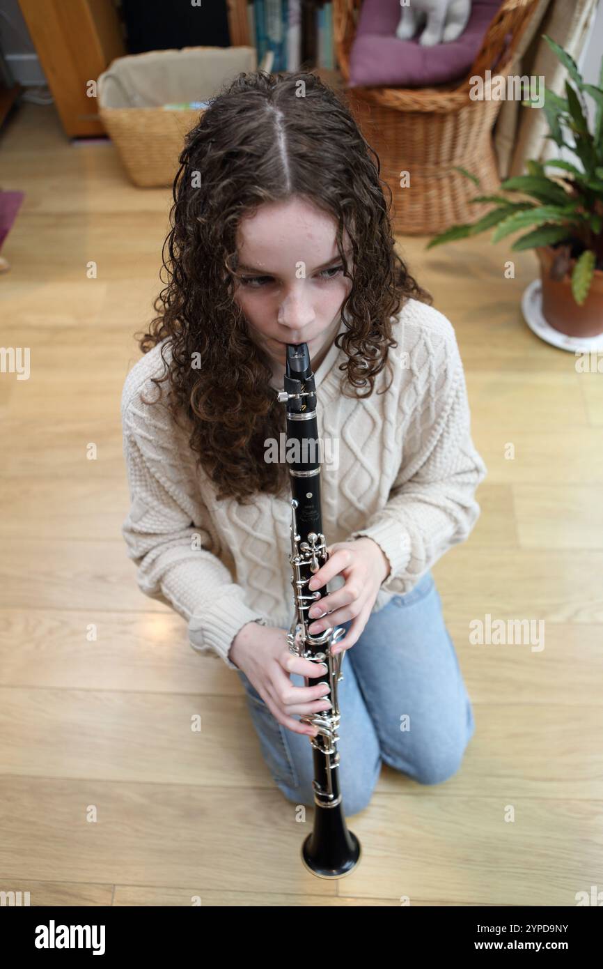 Teenage girl playing clarinet in living room Stock Photo - Alamy