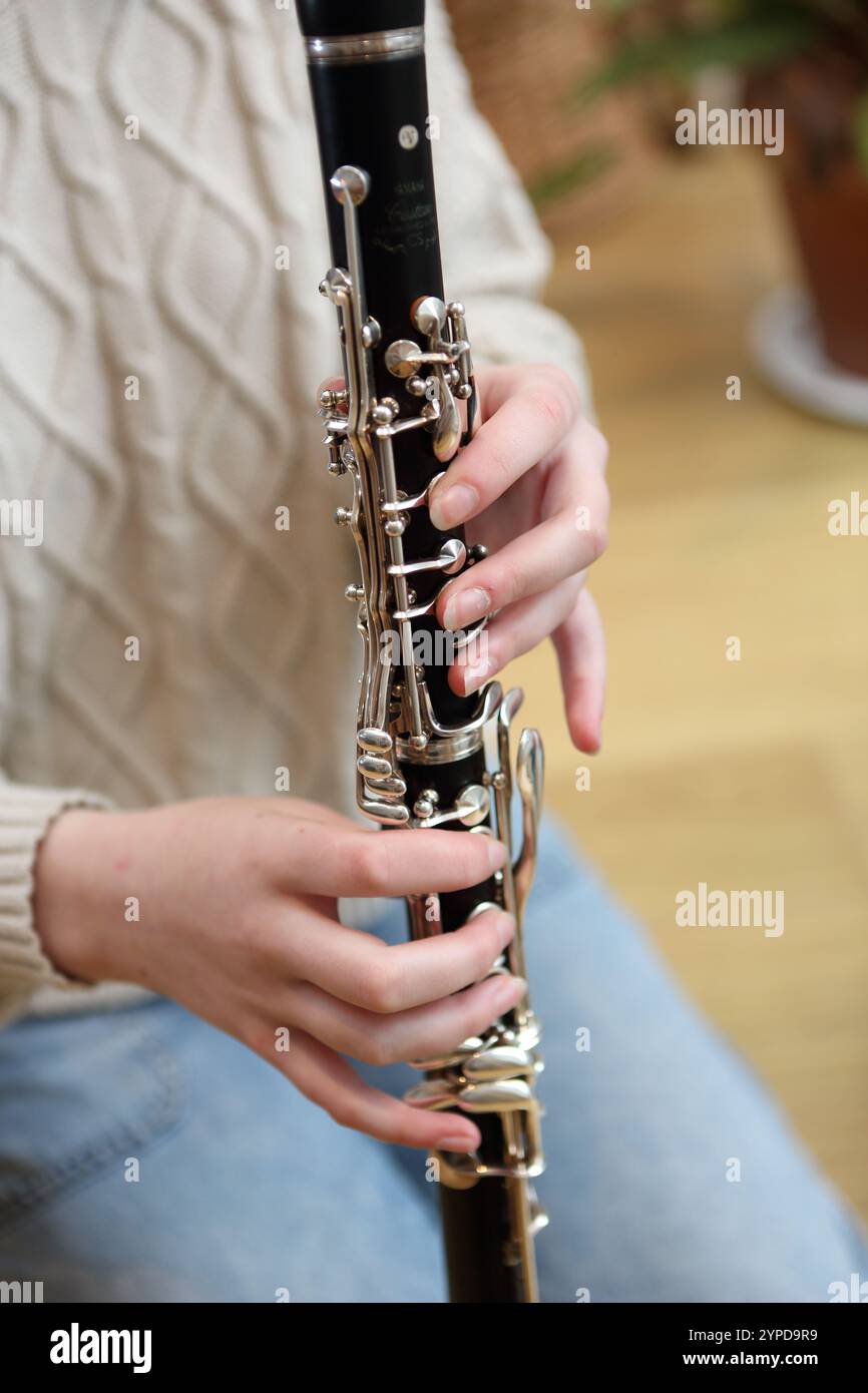 Teenage girl playing clarinet in living room Stock Photo - Alamy